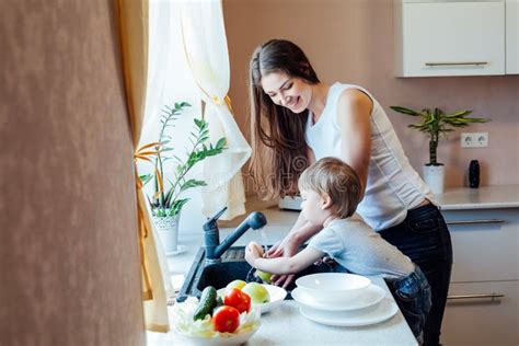 El Niño Está Ayudando A Mamá En La Cocina Foto De Archivo Imagen De