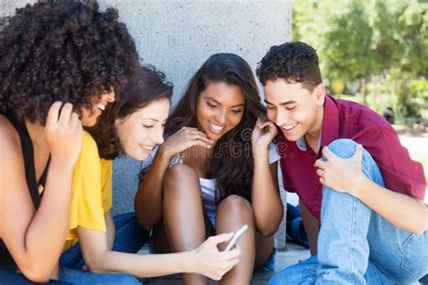 Group Of Multiethnic Young Adult Playing Game With Mobile App Stock