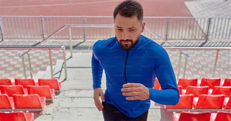 수염을 기른 중년 남자의 초상화 경기장에서 계단을 조깅하며 앞으로 달리고 있다 사진 Unsplash의 경기장 이미지