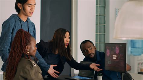 Diverse Team Of Coders Dealing With Security Breach Alert On Computer