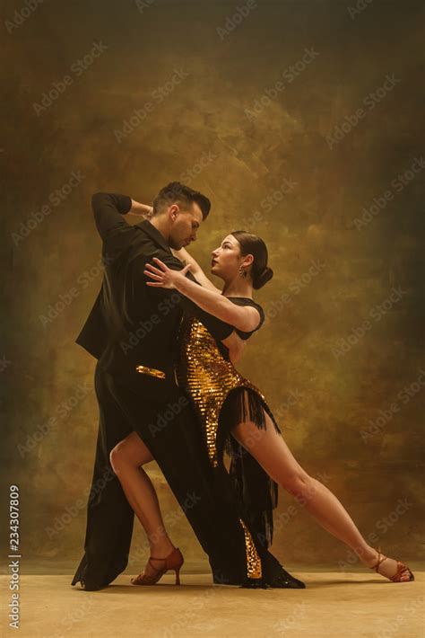 The Young Dance Ballroom Couple In Gold Dress Dancing In Sensual Pose