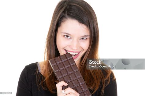 만족 한 예쁜 여자 물고 초콜릿 바 흰색 바탕에 웃 고의 초상화 갈색에 대한 스톡 사진 및 기타 이미지 갈색 귀여운