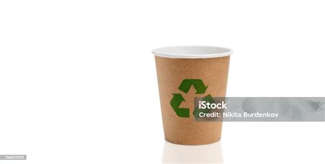 녹색 재활용 표지판이있는 흰색 배경에 생분해성 갈색 종이로 만든 커피를위한 빈 종이 컵 환경을 보호하기 위해 생분해성 물질을 사용하는 개념 환경 보전에 대한 스톡 사진 및
