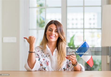 프랑스의 집 지주 국기에서 젊은 여자 손 및 행복 한 얼굴을 미소와 함께 손가락 포인팅 가리키기에 대한 스톡 사진 및 기타 이미지 가리키기 갈색 머리 감정 Istock