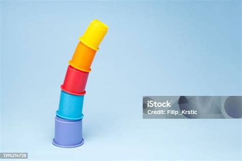 다채로운 경사 타워 무너지는 타워를 구성하는 다양한 색상의 플라스틱 실린더 파란색 배경에 고립 된 떨어지는 물체 건축하기에 대한 스톡 사진 및 기타 이미지 Istock