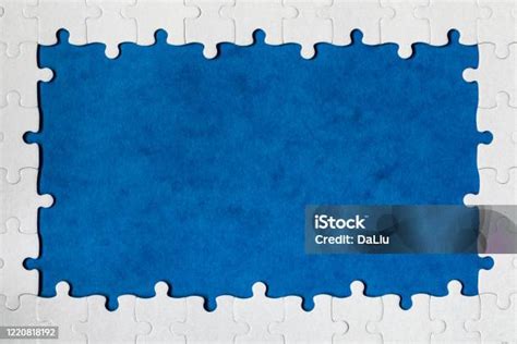 흰색 직소 퍼즐로 만든 사각형의 형태로 프레이밍 프레임 텍스트와 직소 퍼즐 파란색 배경에 직소 퍼즐 조각으로 만든 프레임입니다