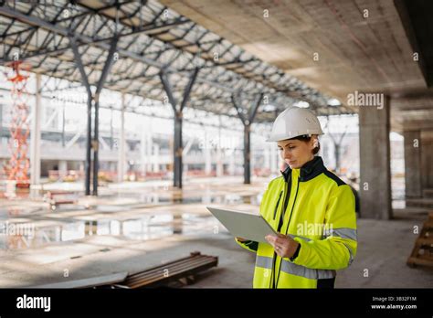Female Engineer Checking Building Documentation On Clipboard At