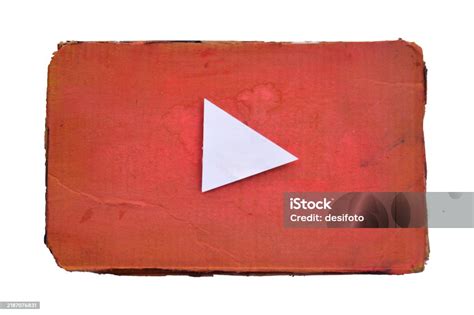 흰 종이를 잘라 퇴색 한 빨간색 골판지 페인트 칠한 재생 버튼 아이콘 기호와 같은 삼각형으로 잘라 낡고 풍화 된 망가진 손상된 수평 판지 배경에 재생 버튼에 대한 스톡 사진