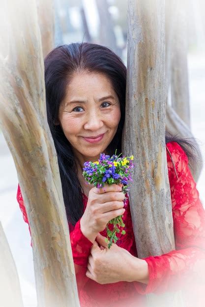 Premium Photo Portrait Of Smiling Young Woman Against Tree Trunk