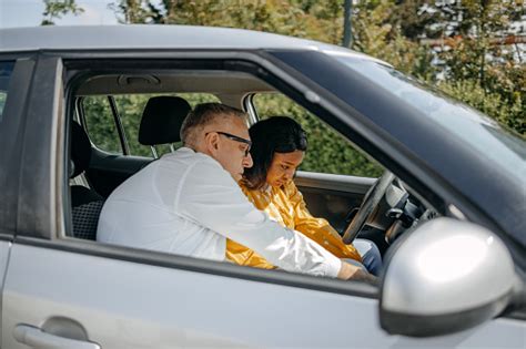 자동차의 다양한 기능을 설명하는 강사와 함께 운전 수업을 받는 젊은 여자 20 24세에 대한 스톡 사진 및 기타 이미지 20
