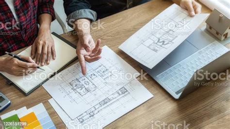 인테리어 디자이너와 건축가는 청사진으로 사무실에서 집 색칠 선택을위한 색상 견본 샘플 차트에서 색상을 선택합니다 건설 개념