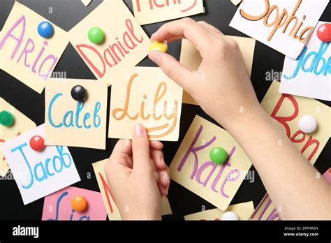 Woman Putting Notes With Baby Names On Board Closeup Stock Photo Alamy
