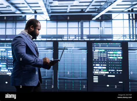 african american man in data center monitoring system performance