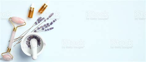 라벤더 꽃 에센셜 오일 파란색 배경에 얼굴 마사지 도구와 박격포 플랫 레이 상단 보기 복사 공간 천연 유기농 Spa 화장품 페이셜 트리트먼트 및 스킨 케어용 미용 제품 0