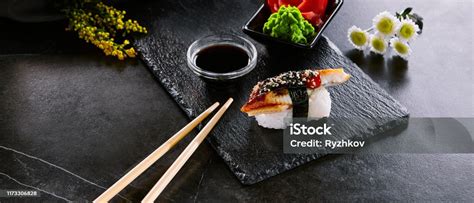 맛있는 일식 장어 클로즈업이있는 초밥 전통 동양 요리 레스토랑 메뉴 항목입니다 동양 요리 나무 접시에 쌀과 소스를 곁들인 맛있는 생선 롤 아시아 전채 우나기 마키 고급