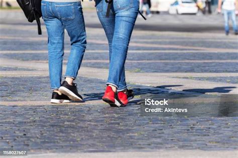 파란 청바지와 스포츠 신발을 입은 두 명의 여성이 여름날 마을 광장을 걷습니다 거리에 대한 스톡 사진 및 기타 이미지 거리 걷기 검은색 Istock