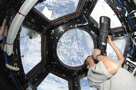 Astronaut photographing aboard the ISS - Stock Image - C007/8552 - Science Photo Library
