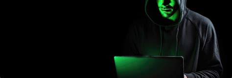 Premium Ai Image Hacker Without Face In A Hood Holds A Laptop On A