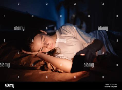 Teen Girl Using A Smartphone While Lying On Bed At Night Female