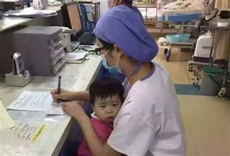 គិលានុបដ្ឋាយិកាម្នាក់បំពេញការងារ ដោយ ស្ពាយ ក្មេង កំព្រាម្នាក់ នៅជាប់ នឹង ដើមទ្រូង Ahladang