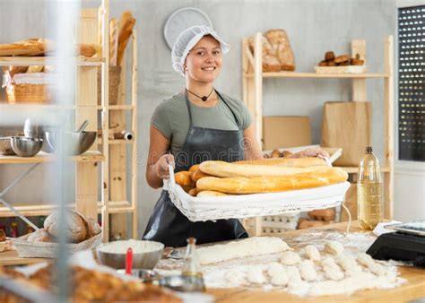 Young Woman Baker Are Standing Near Product Range In Bakery Kitchen