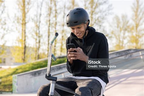 남자는 경사로에 공원에서 Bmx 자전거와 헬멧에 앉아 손에 전화와 텍스트 친구와 스케이트 파크에서 그는 트릭을 할 놀고 두발자전거에 대한 스톡 사진 및 기타 이미지 Istock