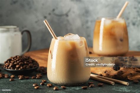 크림이 쏟아진 키가 큰 유리잔에 담긴 아이스 커피 어두운 콘크리트 테이블 위에 얼음 조각과 콩 0명에 대한 스톡 사진 및 기타 이미지 Istock