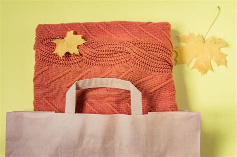 가 단풍나무와 노란 배경에 종이 공예 패키지 오렌지 여자 따뜻한 스웨터 나뭇잎 장식 의류 판매 고 검은 금요일 개념입니다 최고의 볼 수 있습니다 0명에 대한 스톡 사진 및