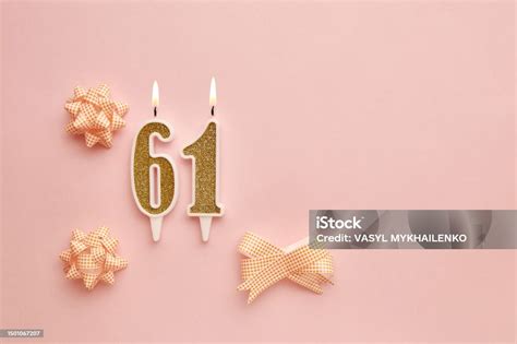 축제 장식이 있는 파스텔 핑크 배경에 숫자 61이 있는 양초 생일 축하 촛불 생일 기념일 중요한 날짜 휴일을 축하하는 개념입니다 복사 공간 기치 1에 대한 스톡 사진 및