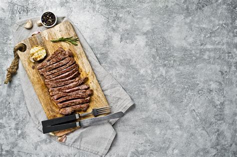 얇게 썬 소고기 플 랭크 스테이크를 목 제 마에 회색 배경 평면도 텍스트 공간 고기에 대한 스톡 사진 및 기타 이미지 고기