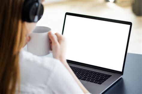 헤드폰을 끼고 빈 노트북 화면을 보고 웨비나 교육이나 온라인 작업을 시청하는 여성 복사 공간 모형 컴퓨터에 대한 스톡 사진 및