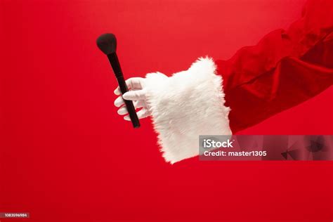 빨간색 배경에 분말 메이크업 브러쉬를 들고 하는 산타 클로스의 손 12월에 대한 스톡 사진 및 기타 이미지 12월 개성 개념 겨울 Istock