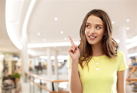 Premium Photo Teenage Girl Pointing Finger Up In Shopping Mall