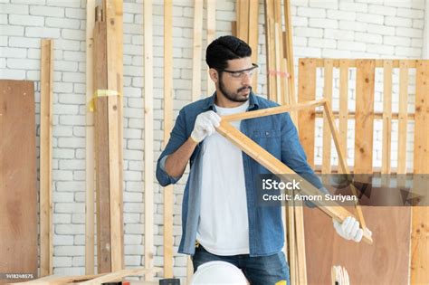 목수 남자는 목재 작업장에서 목공예 가구를 작업하고 점검합니다 아시아 남성 목수 노동자는 목공 공장에서 안전 장비 공구 작업을