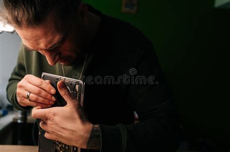 Computer Technician Carefully Examining And Repairing Components Inside Laptop During