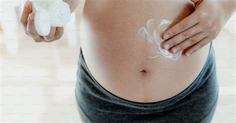 행복한 임산부는 튼살을 방지하기 위해 임신한 배에 스킨케어 크림 로션을 바릅니다 건강한 피부 마사지 트리트먼트와 수분 관리 개념 사진 Unsplash의 임신한 이미지