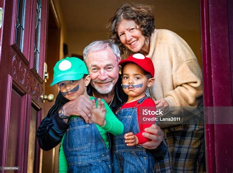 할로윈을 위해 옷을 입은 백인 조부모와 아프리카 계 미국인 쌍둥이 소년 손자의 초상화 할로윈에 대한 스톡 사진 및 기타 이미지