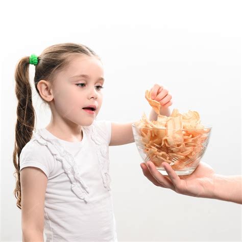 A La Niña Se Le Da Un Gran Tazón De Bocadillos De Papas Fritas Con