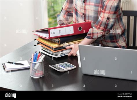 Businesswoman Putting A Stack Of Binders And Folders On Her Desk Stock Photo Alamy