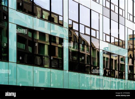 Modern Glass Facade With Reflective Panels And Angular Architectural Details In Urban Design