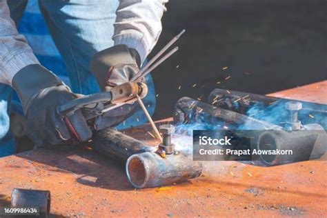 건설 현장 지역의 금속 조인트에 적용하기 위해 아연 도금 강관의 용접 너트와 볼트에 아크 용접기를 사용하여 용접기 손을 닫습니다 가죽에 대한 스톡 사진 및 기타 이미지