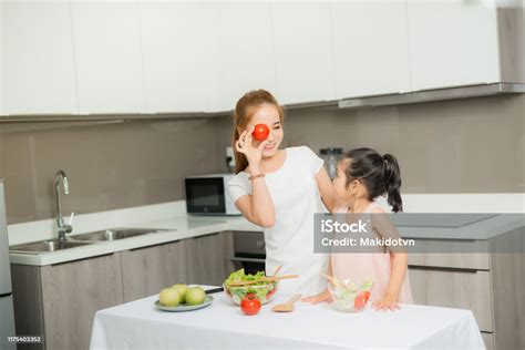귀여운 어린 소녀와 요리사의 모자에 그녀의 엄마는 샐러드를 요리야채를 절단하고 미소 가정 생활에 대한 스톡 사진 및 기타 이미지