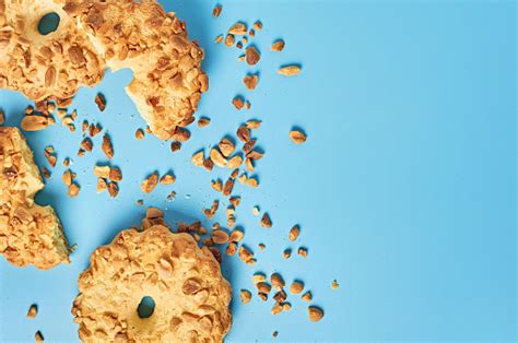 땅콩과 부스러기가있는 신선한 원 귀리 쿠키의 전체 및 반쪽은 부엌의 파란색 책상에 놓여 있습니다 텍스트의 공백입니다 맨 위 보기 건강한 식생활에 대한 스톡 사진 및 기타