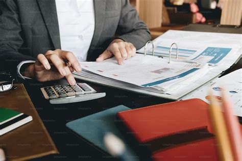 계산기를 사용하여 재무 문서 재무 회계 개념의 숫자를 계산하는 사업가 사진 Unsplash의 문서 이미지