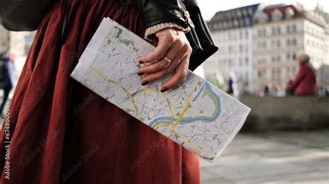 Female Tourist Strolls Through Central Streets In Dresden Carrying City Map With Sightseeings