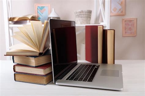 Premium Photo Stack Of Books With Laptop On Table Close Up