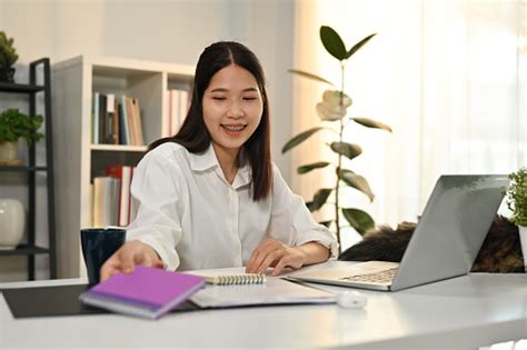 밀레니얼 세대의 아시아 여성들이 홈 오피스의 하얀 책상에 노트북을 사용하고 있다 기술 프리랜서 및 원격 작업 개념입니다 25 29세에 대한 스톡 사진 및 기타 이미지