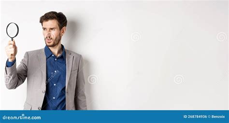 Serious Man In Suit Searching For Clues Through Magnifying Glass