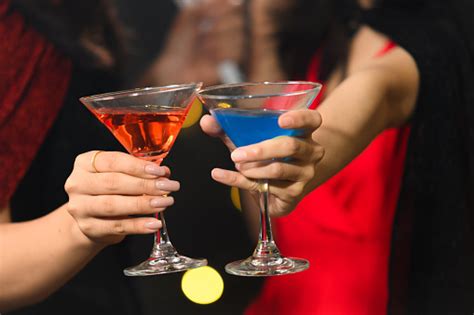 어두운 마법의 배경을 통해 할로윈 파티에서 마녀 할로윈 의상을 입은 두 젊은 여성의 클로즈업 다채로운 칵테일 안경 휴일 파티 개념 2명에 대한 스톡 사진 및 기타 이미지