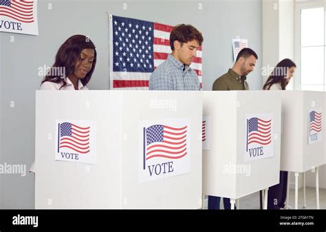 American Citizens Standing At Vote Center In Voting Booth Putting